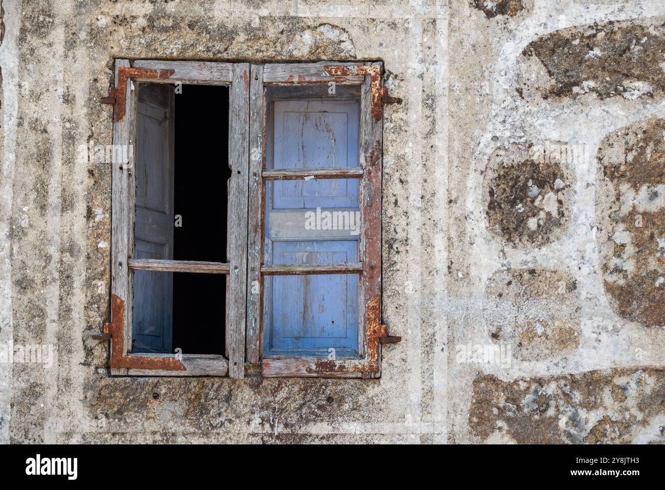 Picturesque rustic old window with wooden frames and blue shutters in a ...