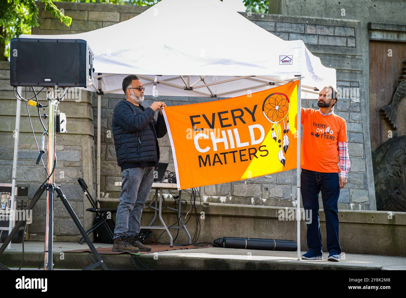 Organizers hang an Every Child Matters banner at the start of the ...