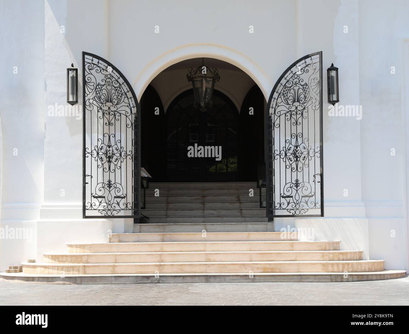 The main entrance of elegance white building. Steps to opened wrought ...