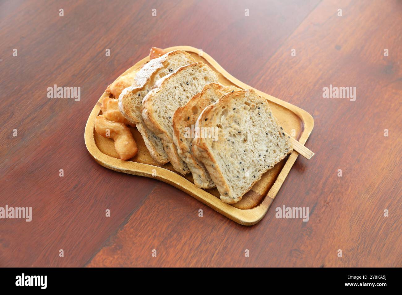Homemade fresh sliced bread in a wooden tray on table Stock Photo - Alamy