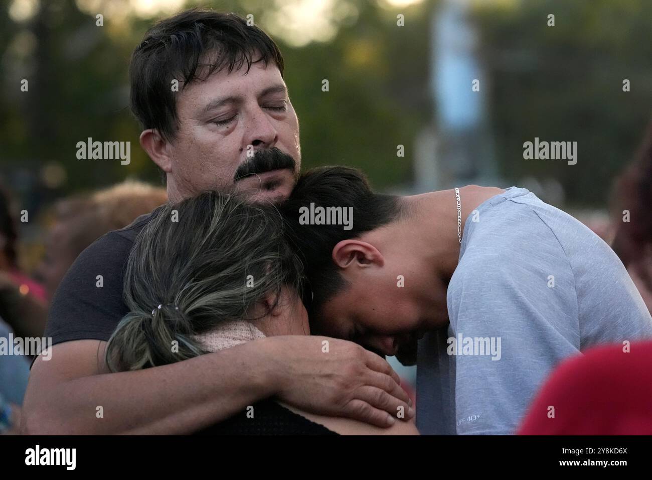 Daniel Delgado, top, is comforted by his 16-year-old son Angel Delgado, right, as he mourns the ...