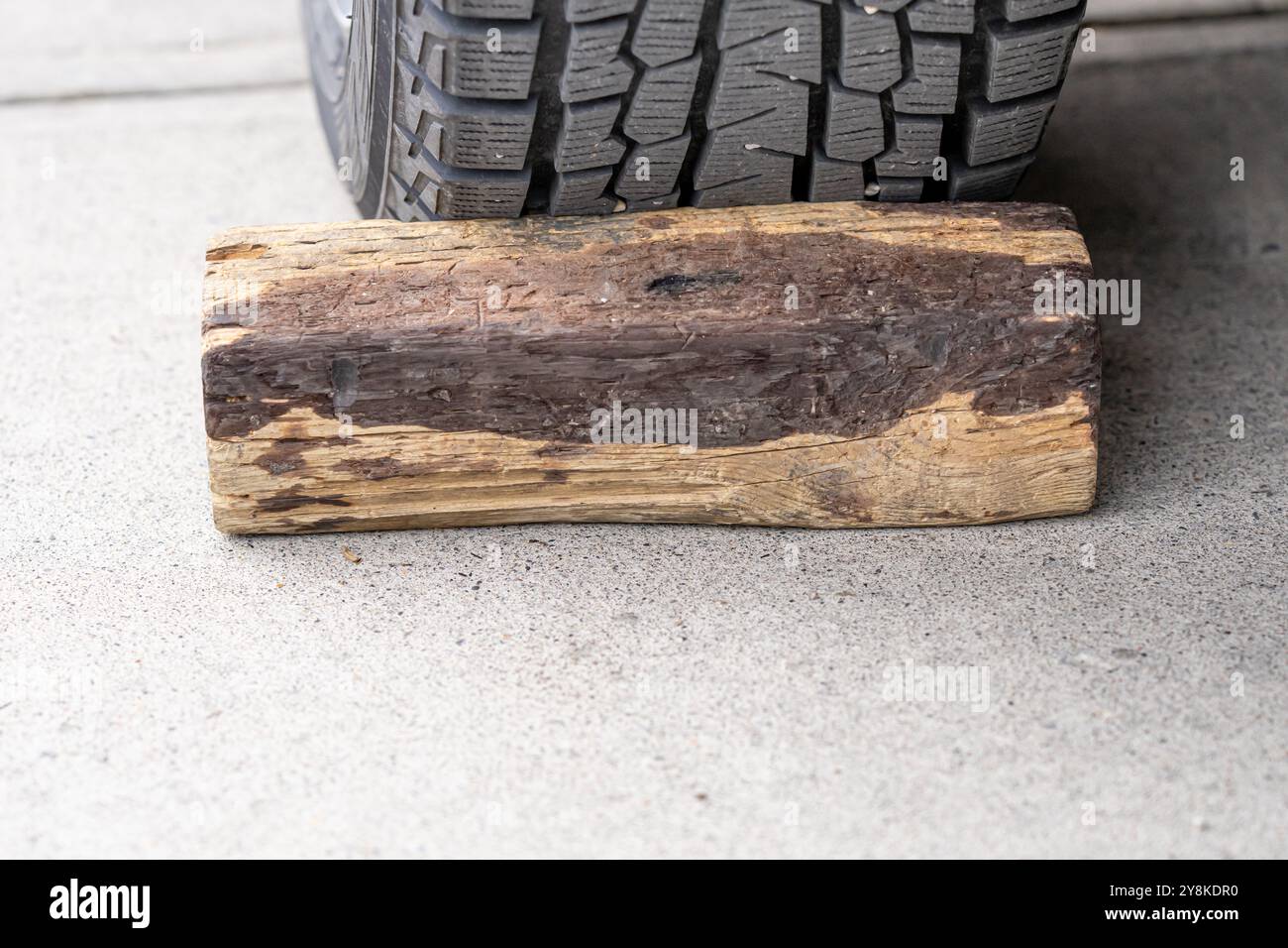 wood car chock to stop car from rolling away Stock Photo - Alamy