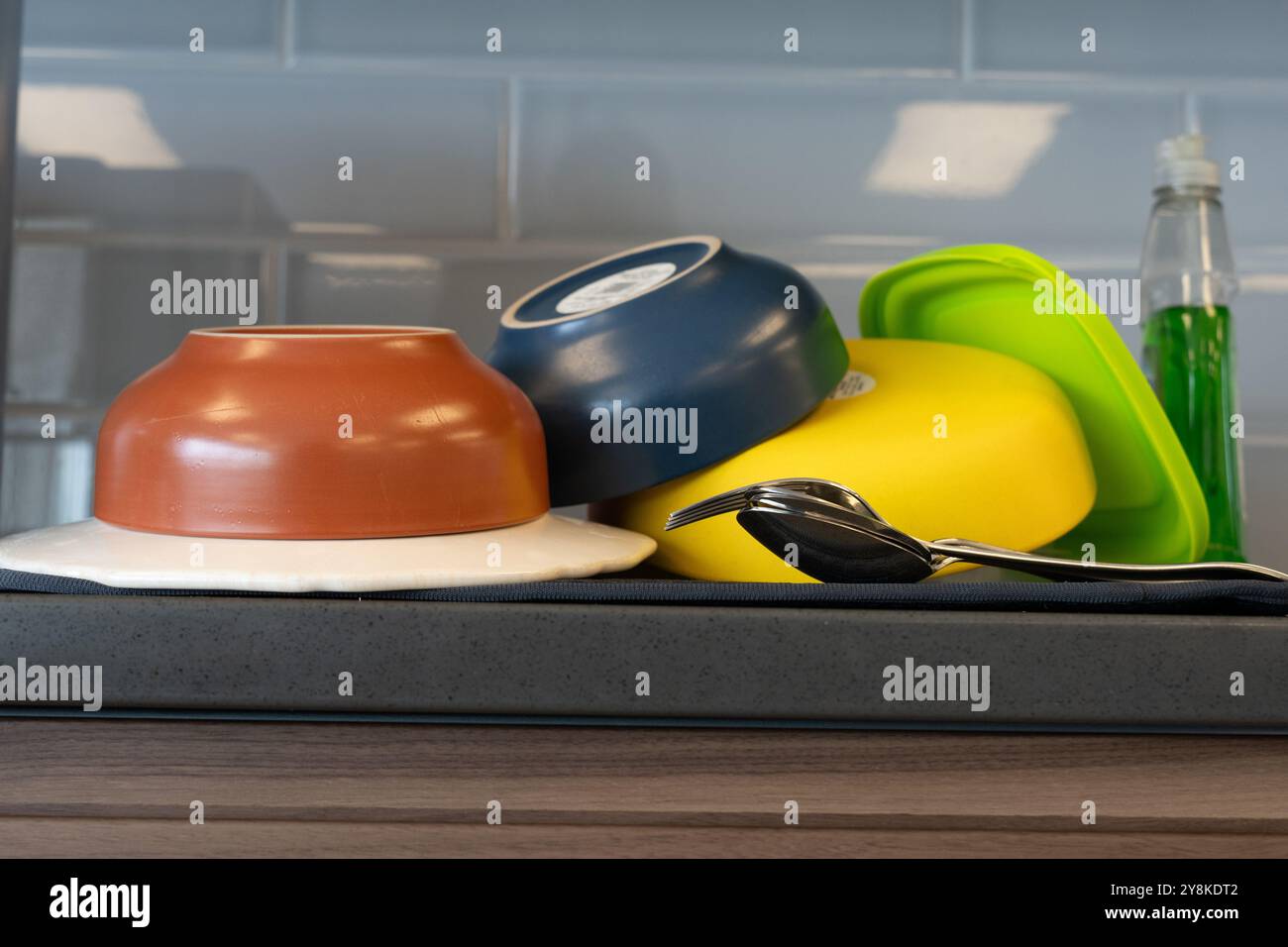 stack of washed plates and cutlery on kitchen counter Stock Photo - Alamy