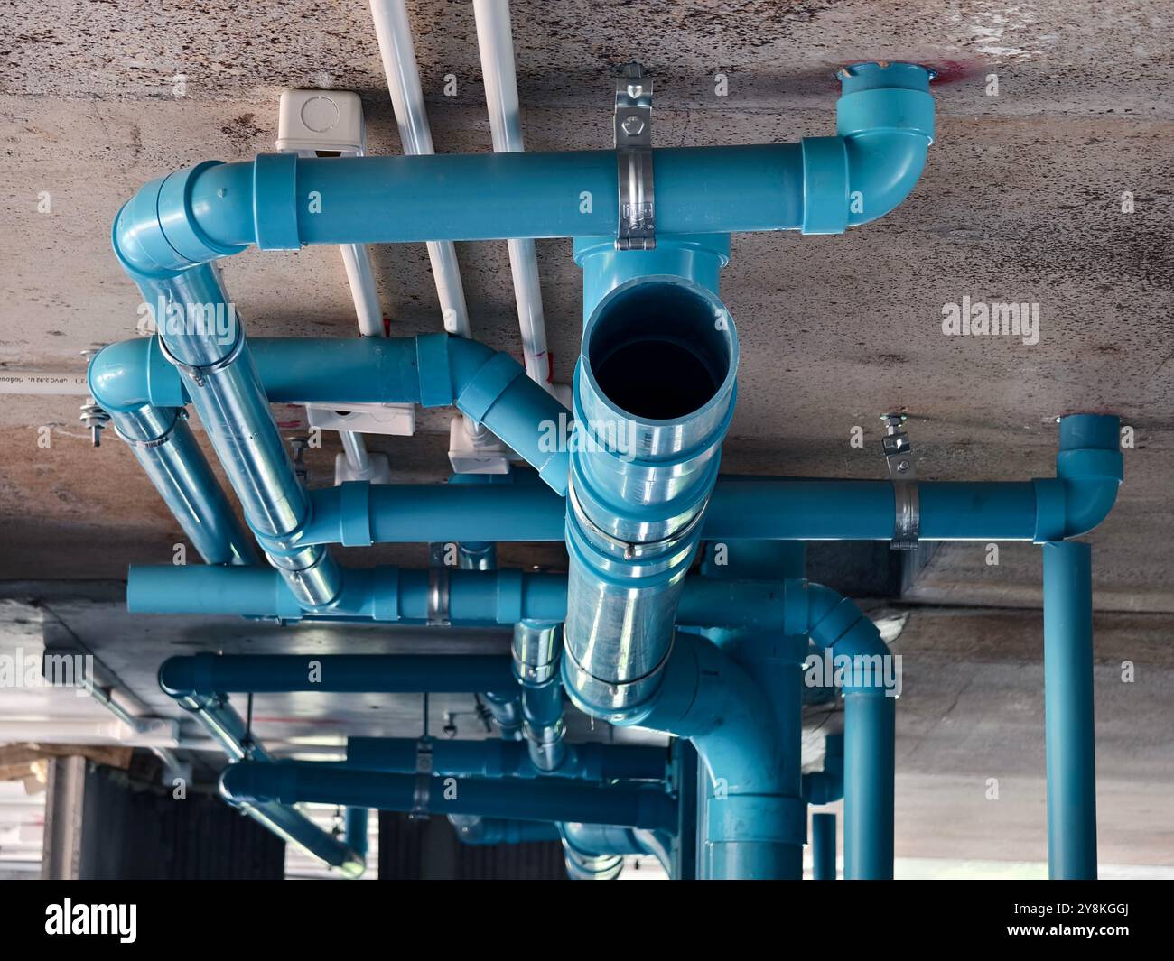 A bright blue pipes attached to a solid concrete wall Stock Photo - Alamy