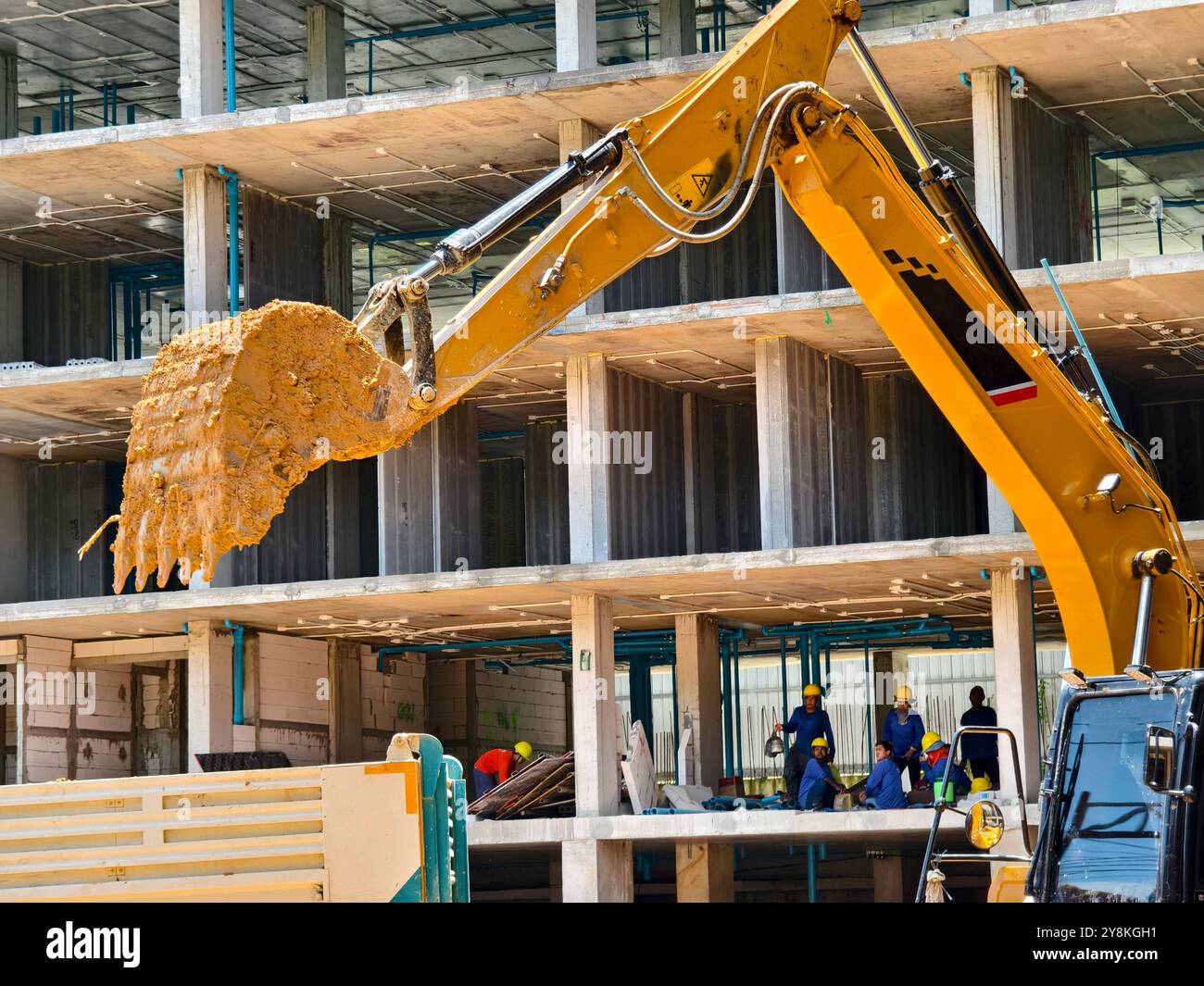 Excavator loads ground into a dump truck at a construction site Stock ...