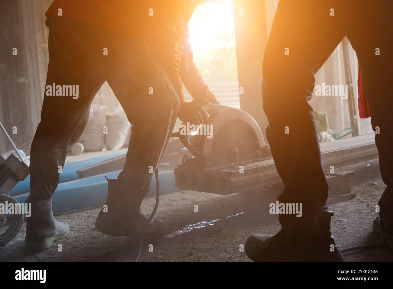 A builder using a circular saw to cut a large concrete piece Stock ...