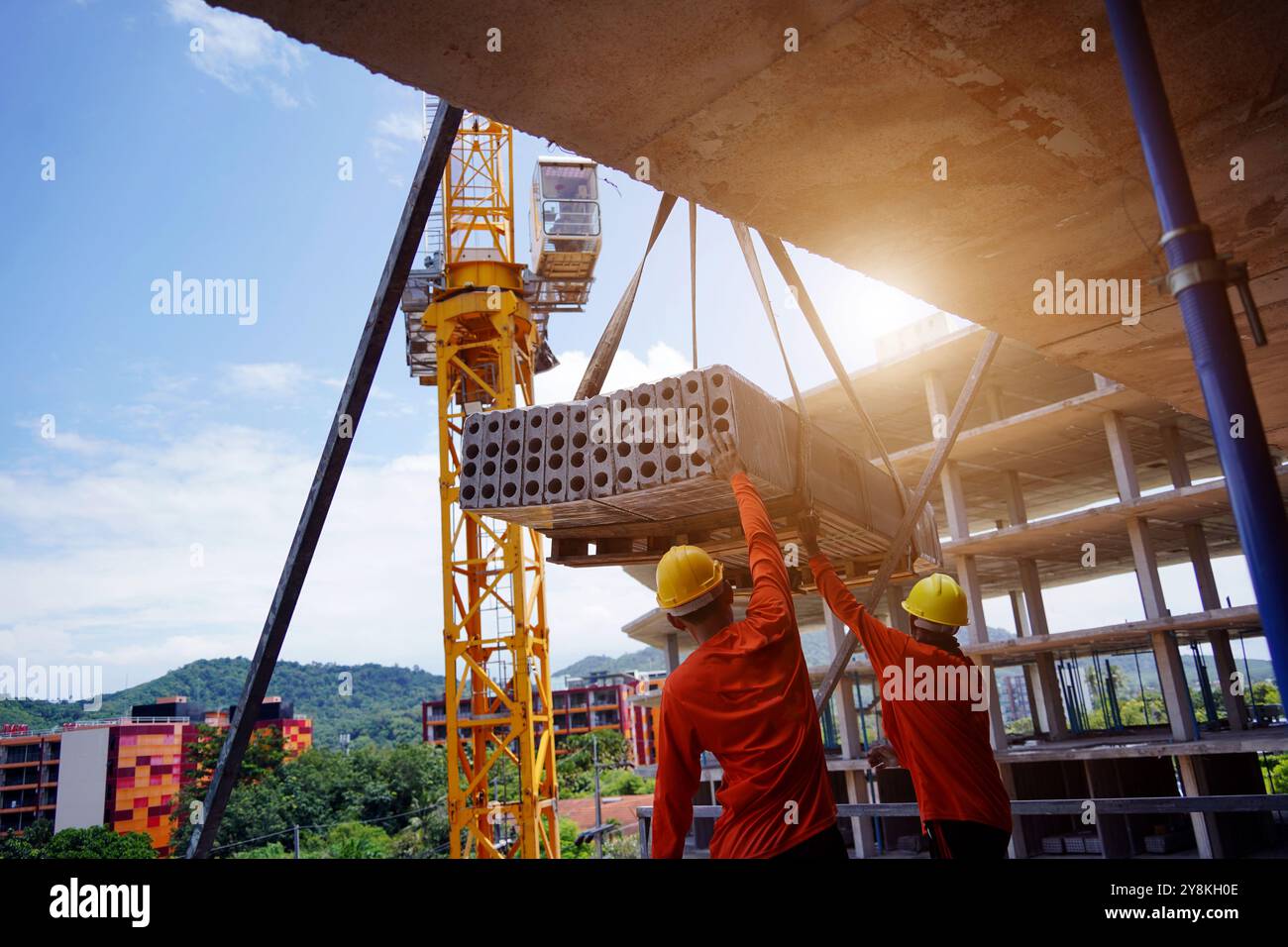 Workers at a building under construction take slabs from a crane Stock ...