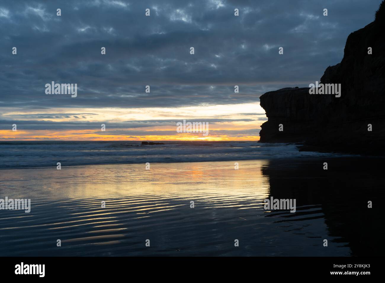 Auckland, New Zealand. Sun sets at Muriwai Beach Stock Photo - Alamy
