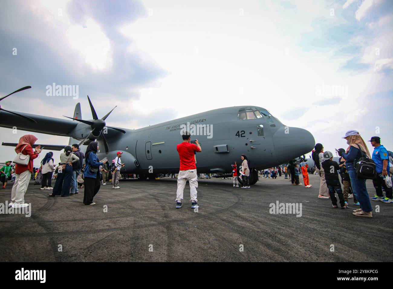 People take photos in front of a plane belonging to the Indonesian ...