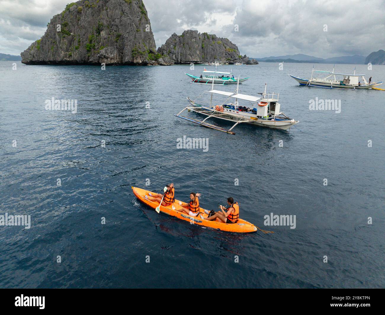 Kayak and Tourist Boat over the blue sea near the Twin Rocks. El Nido ...