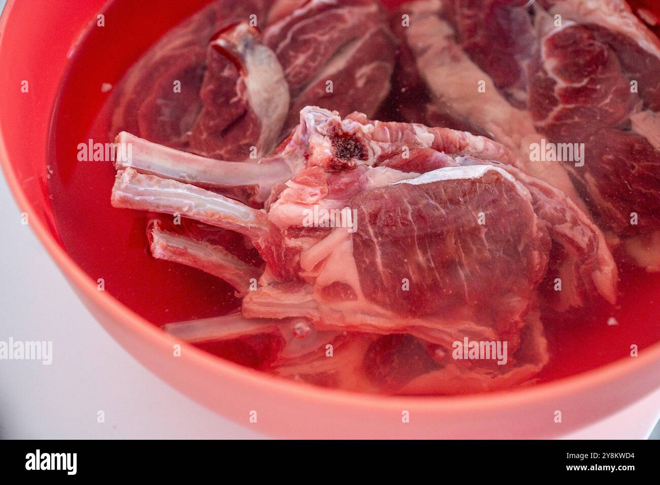 Raw beef meat is defrosted in water. meal concept Stock Photo - Alamy