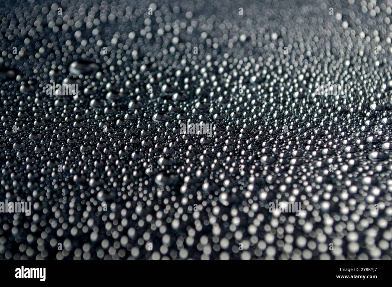 Side view of tiny water droplets on a windshield. Rain patterns concept ...