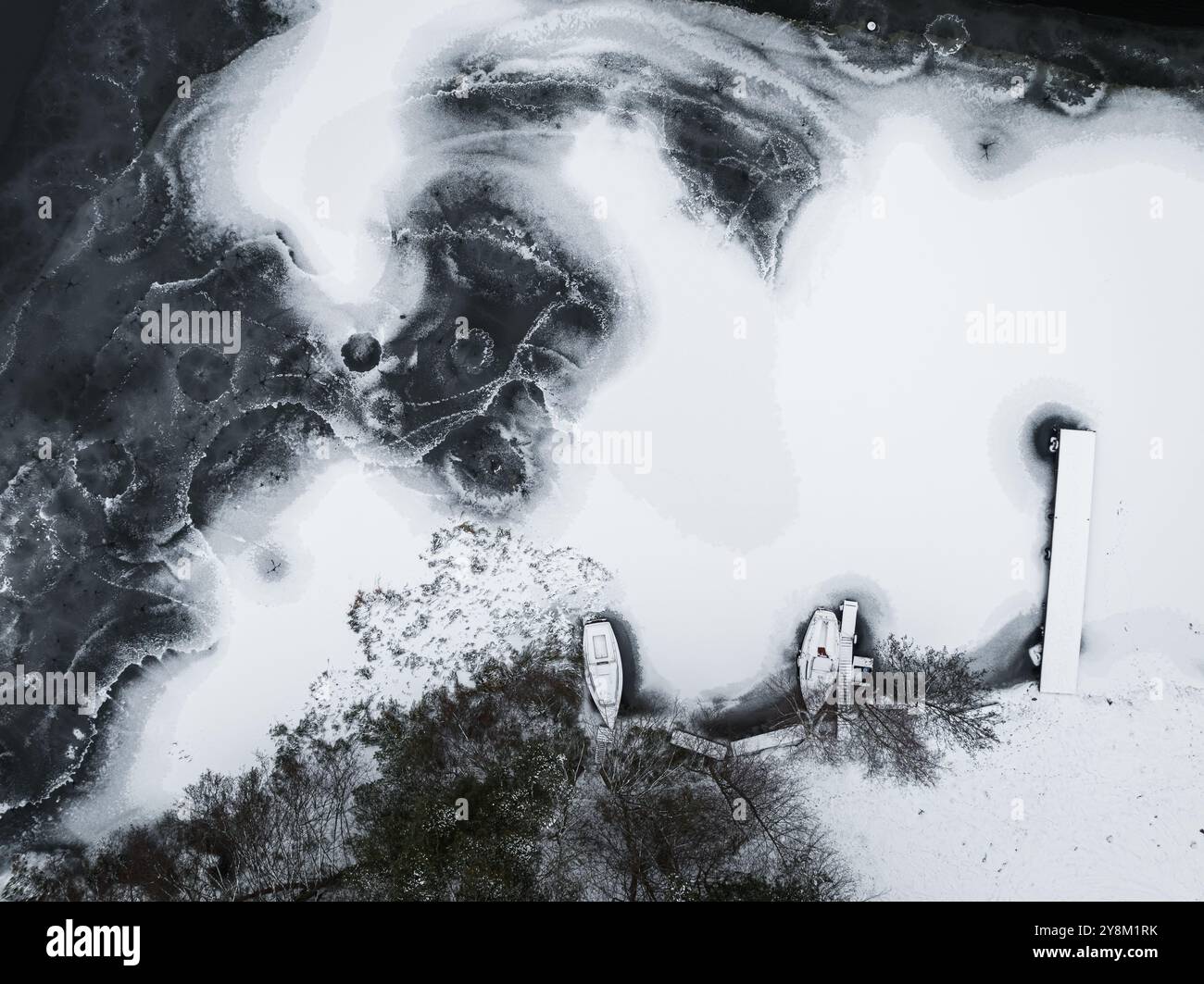 Aerial view of pier on a frozen river with melting ice. Wildlife in ...