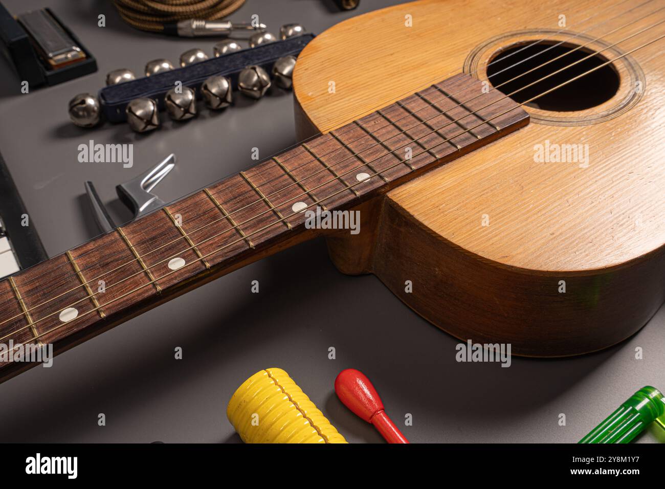 Close-up of acoustic guitar with wooden fretboard alongside various ...
