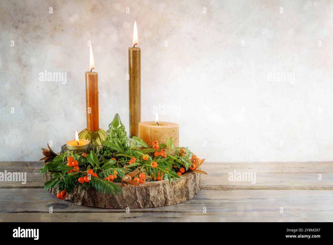 Four variations of candles with natural green branches and orange ...