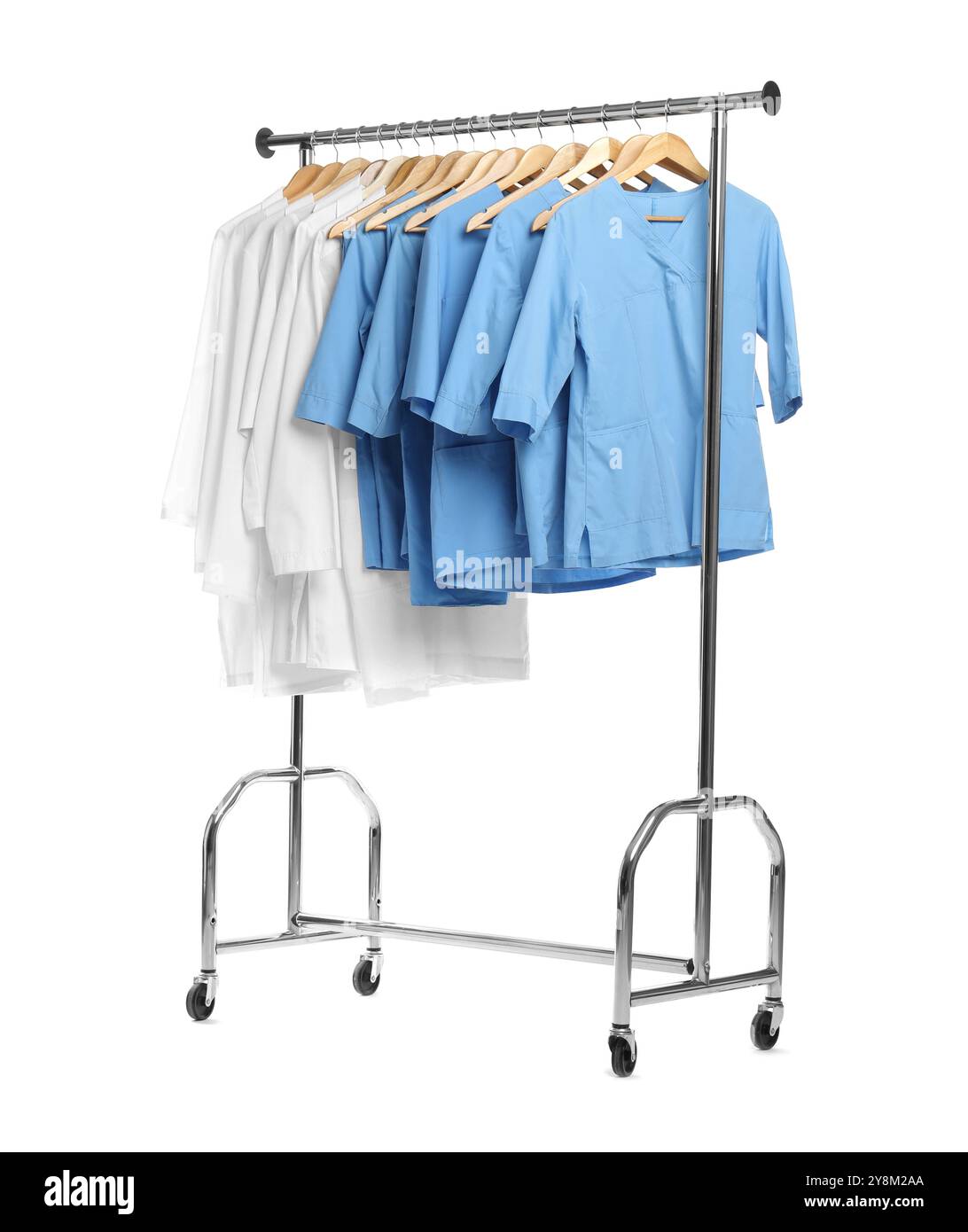 Different medical workers' uniforms on clothing rack against white ...