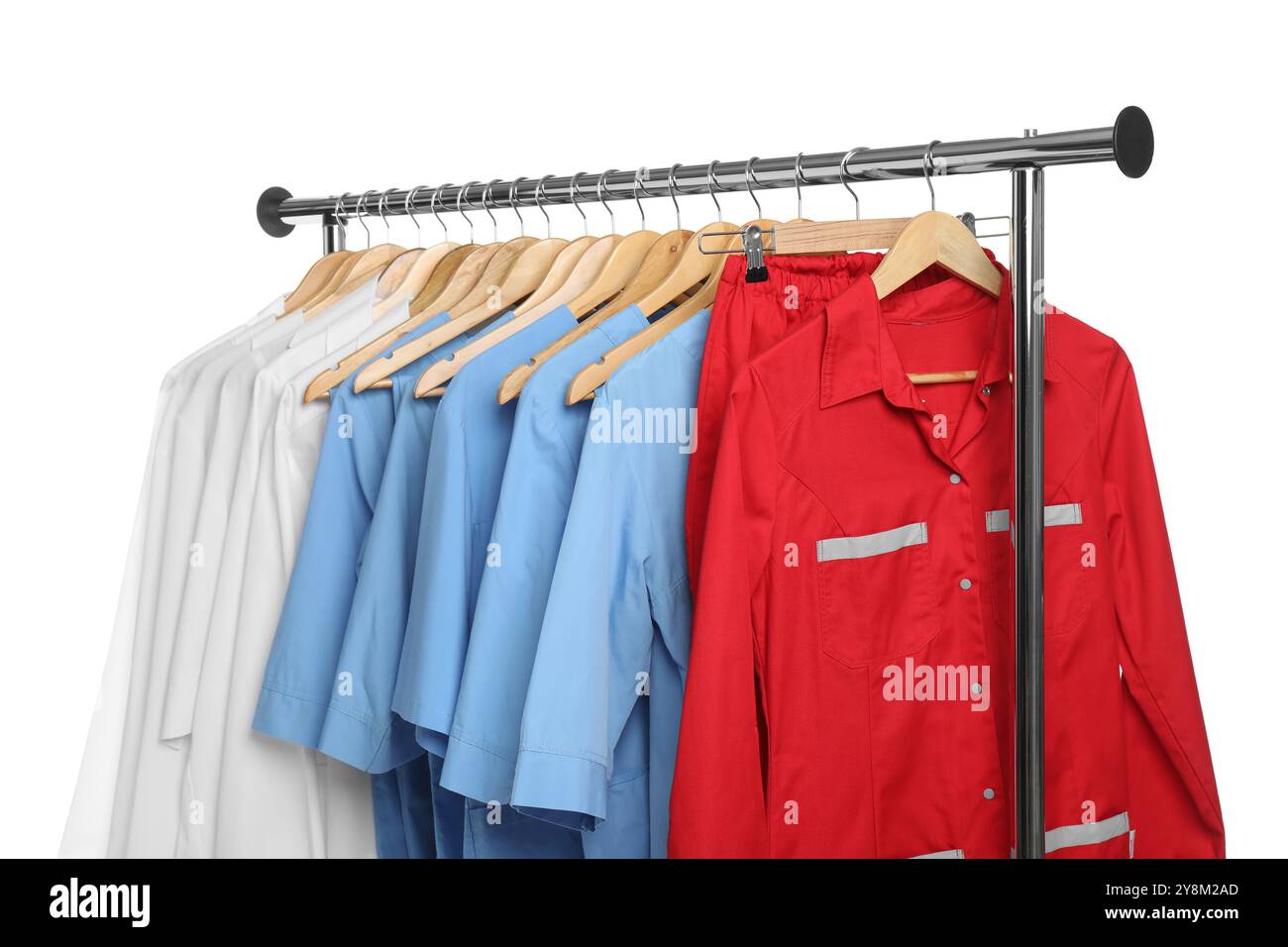 Different medical workers' uniforms on clothing rack against white ...