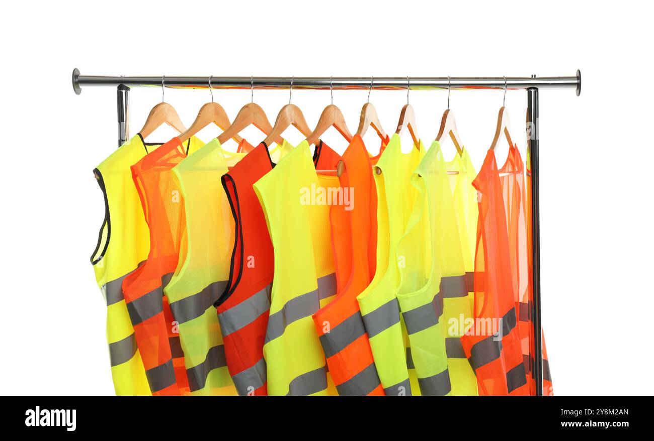 Different bright reflective vests on clothing rack isolated on white ...