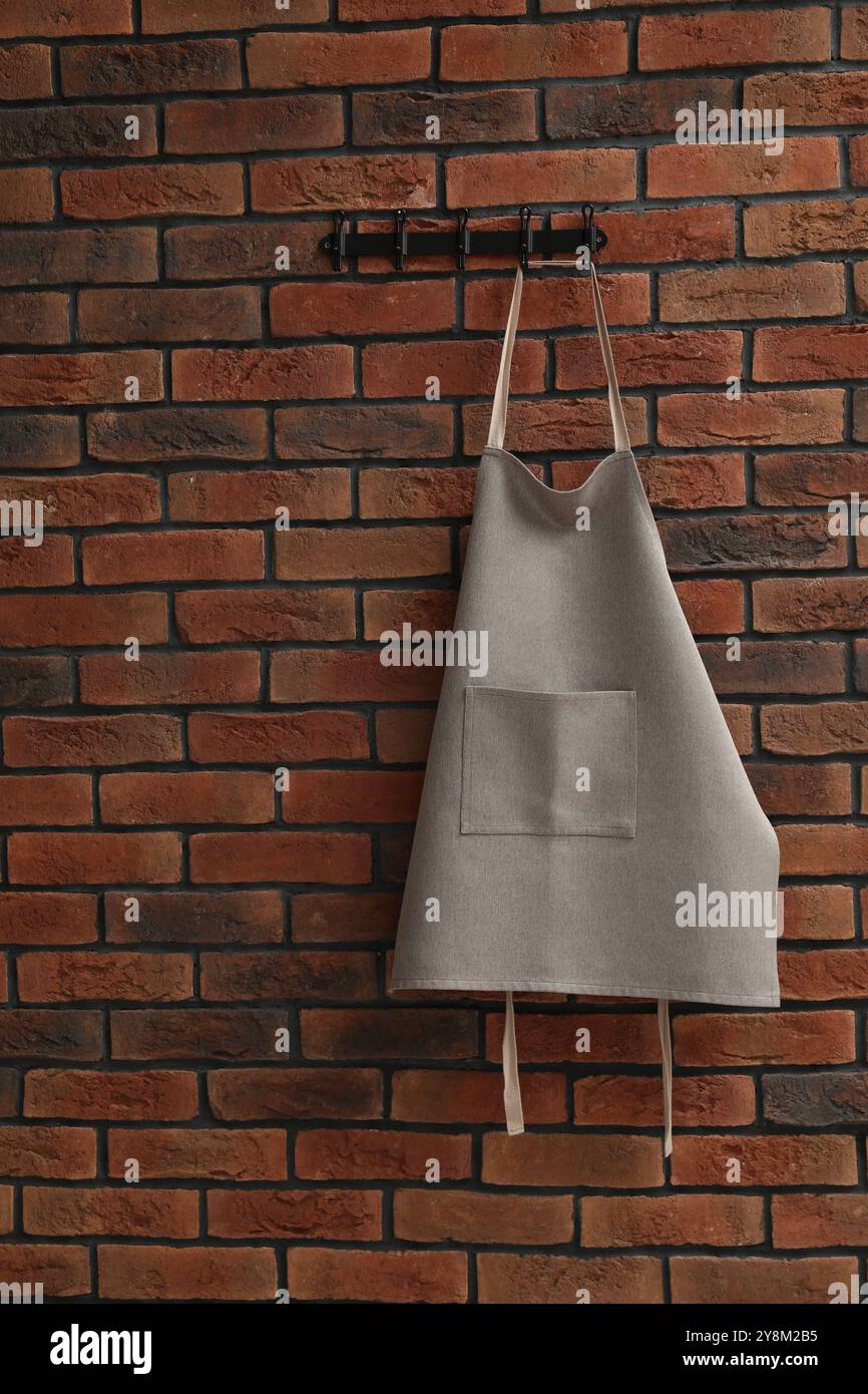 One chef's apron hanging on brick wall Stock Photo - Alamy