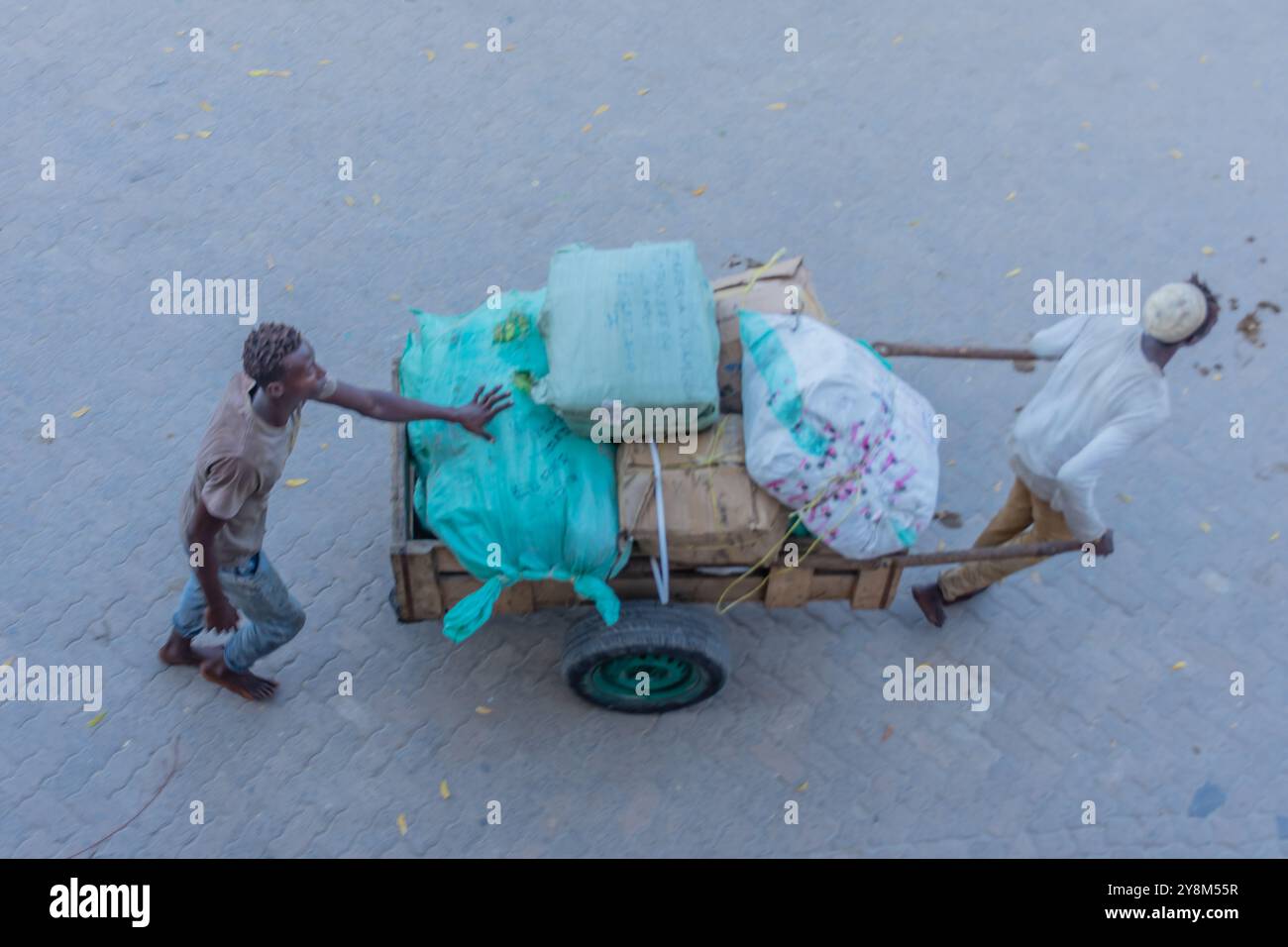 Two man transport goods using a push cart Stock Photo - Alamy