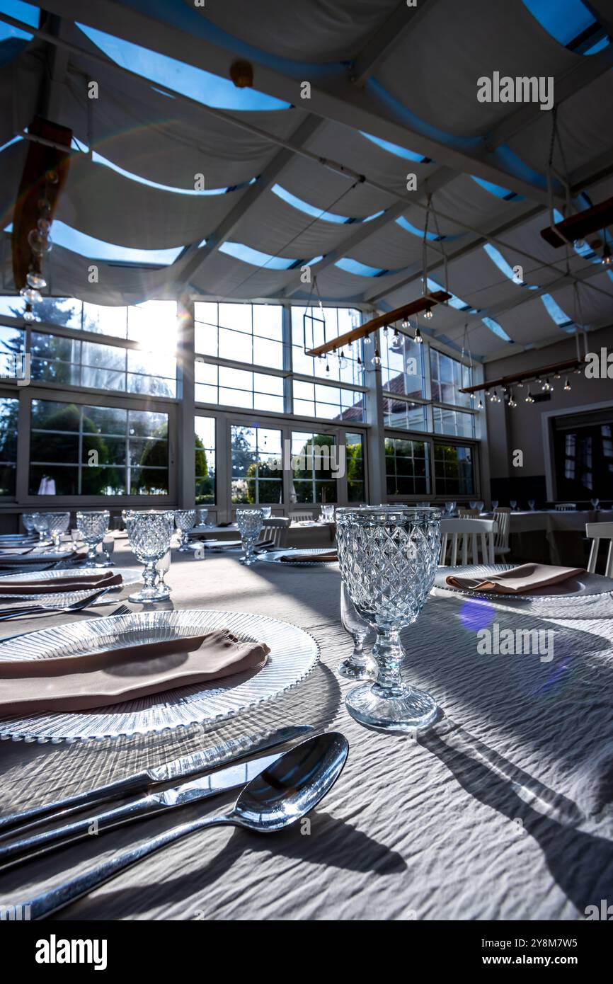 Crystal glass on the table in a bright, glass-walled banquet hall ...