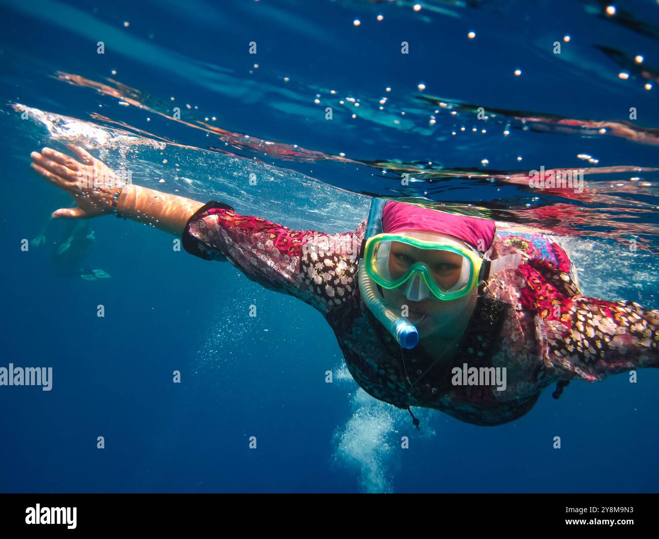 A snorkeling woman swims in a blue water of the ocean. Snorkeling in ...