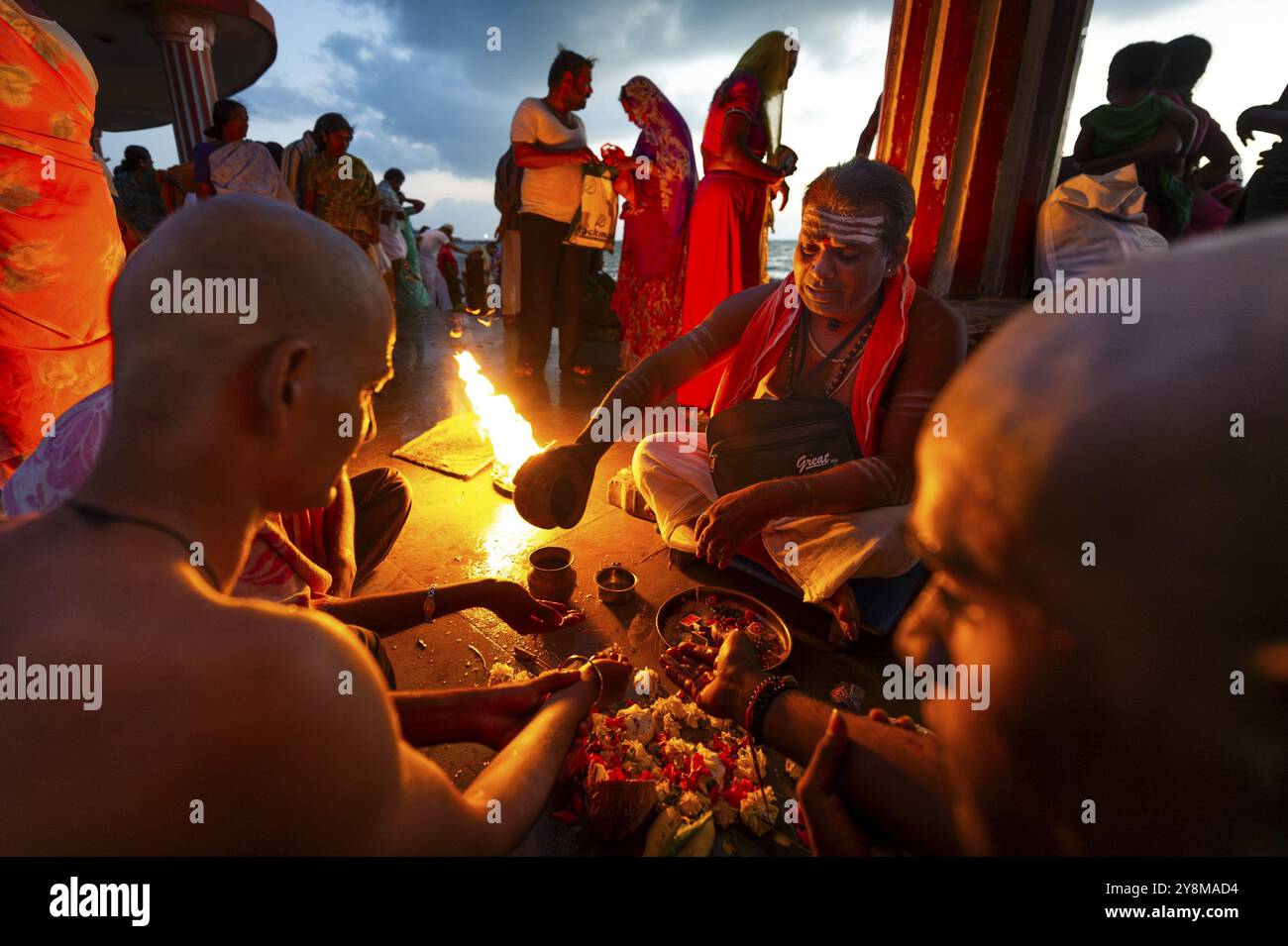 Hindu priest with pilgrims at the fire ritual at Ghat Agni Theertham ...