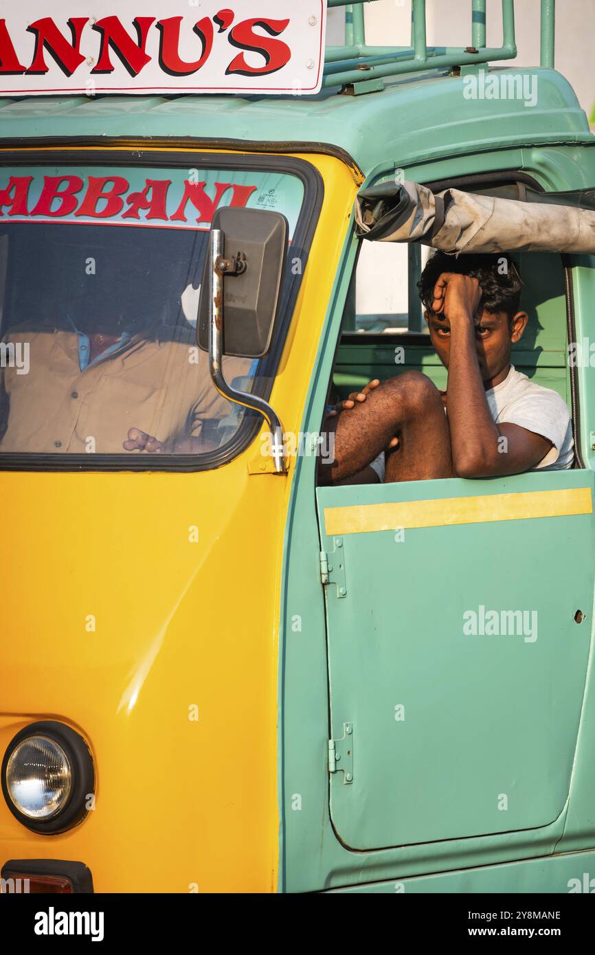 Young man in a yellow-green cargo rickshaw, Fort Cochin, Kochi, Kerala ...