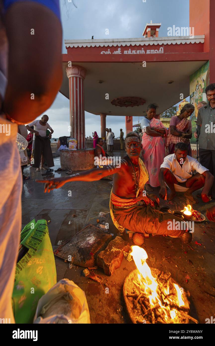 Hindu priest with pilgrims at the fire ritual at Ghat Agni Theertham ...