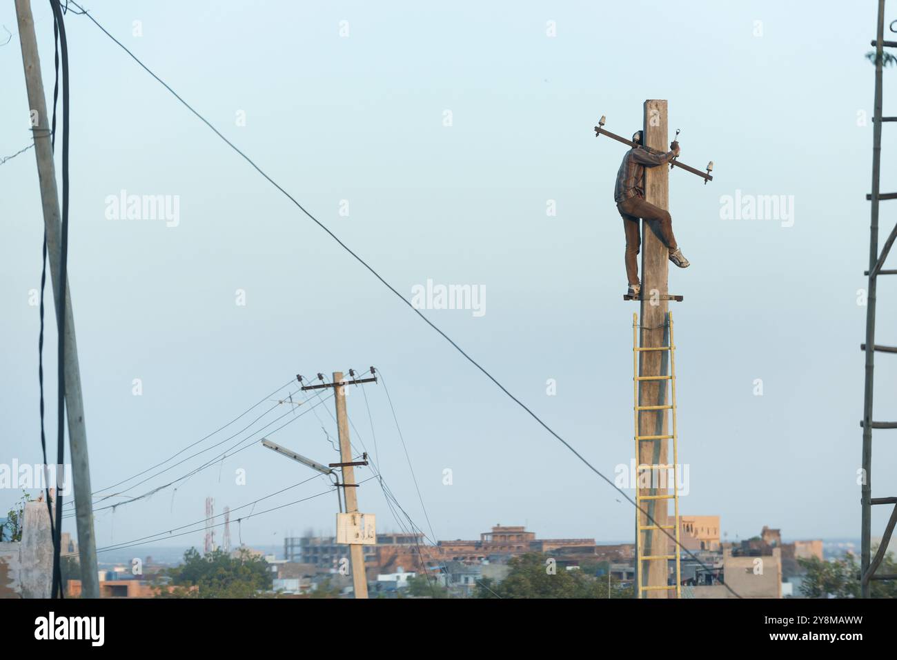 Man repairing a power line on a high voltage pylon, Jodhpur, Rajasthan ...