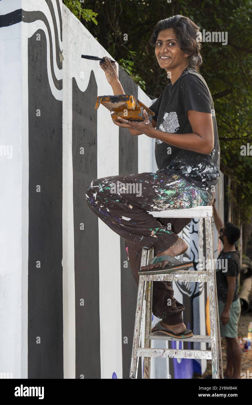 Indian artist painting a wall during the international contemporary art ...