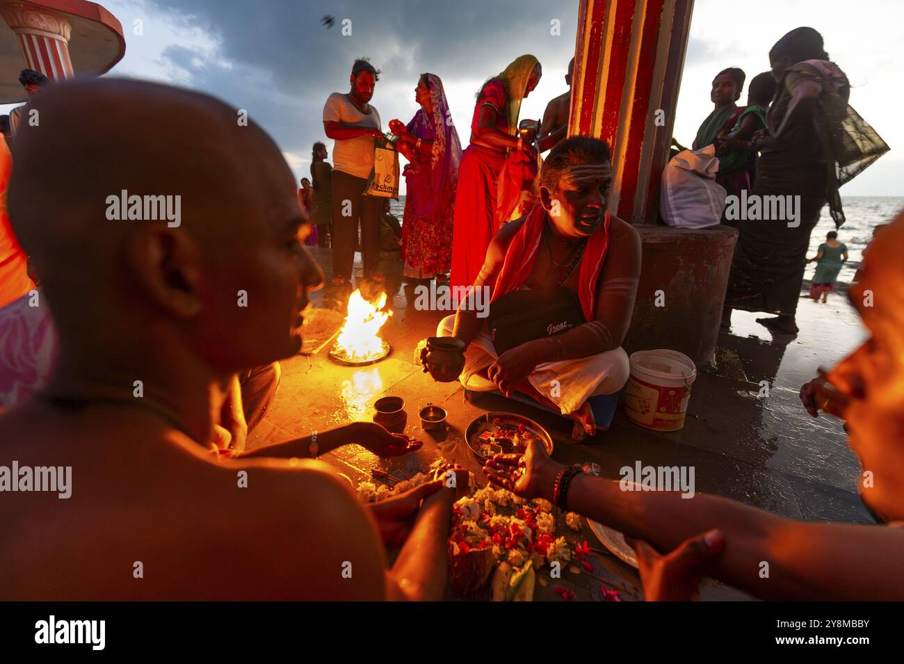 Hindu priest with pilgrims at the fire ritual at Ghat Agni Theertham ...