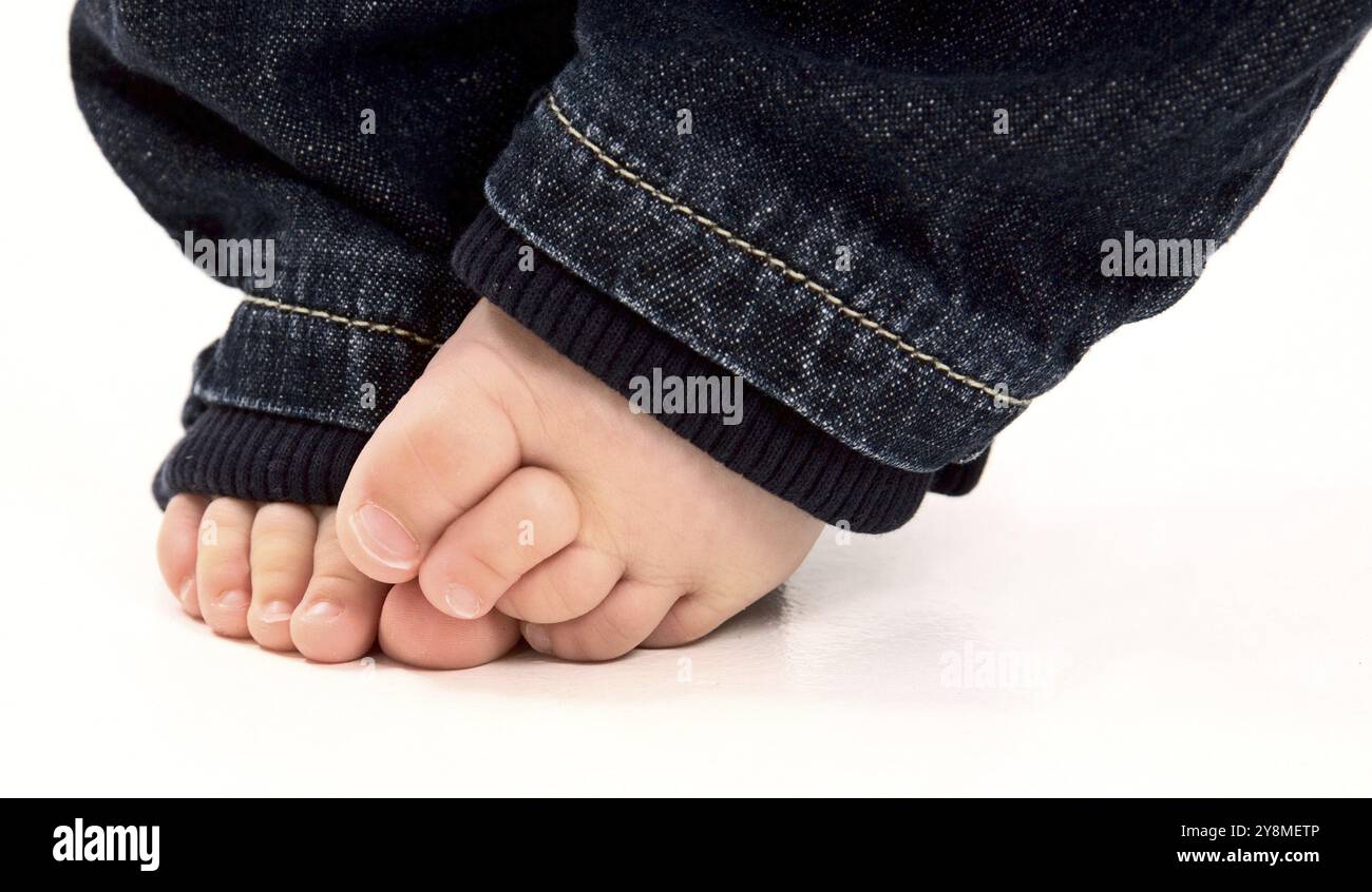 Baby feet and denim young toes and blue jeans Stock Photo - Alamy