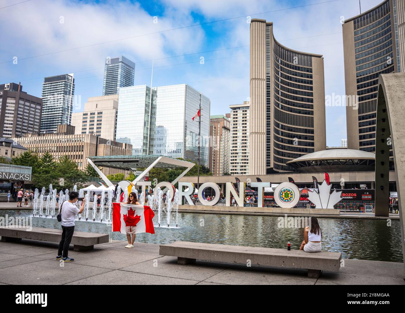 A young woman unfurls a Canadian flag in Nathan Phillips square near ...