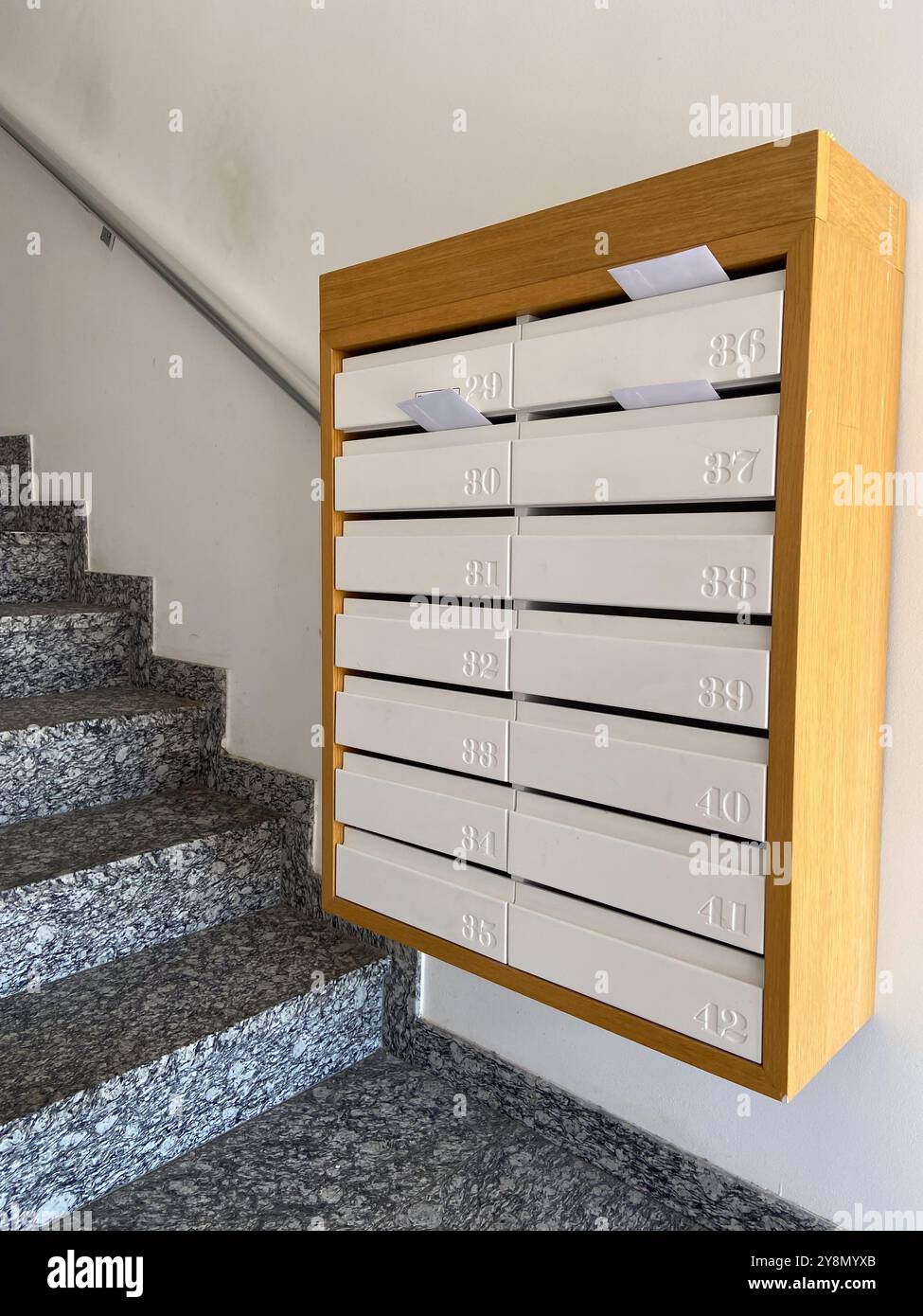 Row of mailboxes in a modern apartment building, with letters sticking ...