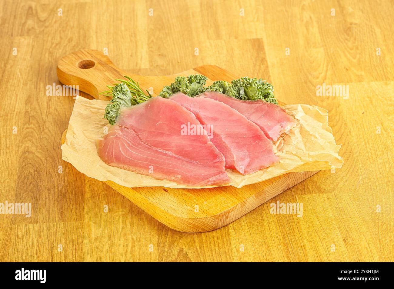 Raw salted tuna slice over board snack Stock Photo - Alamy