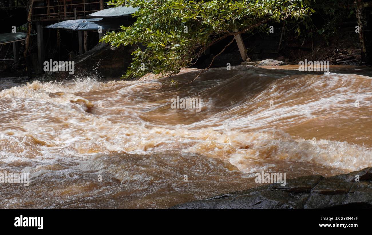 A strong current near a waterfall. Floods flowing in mountain rivers ...