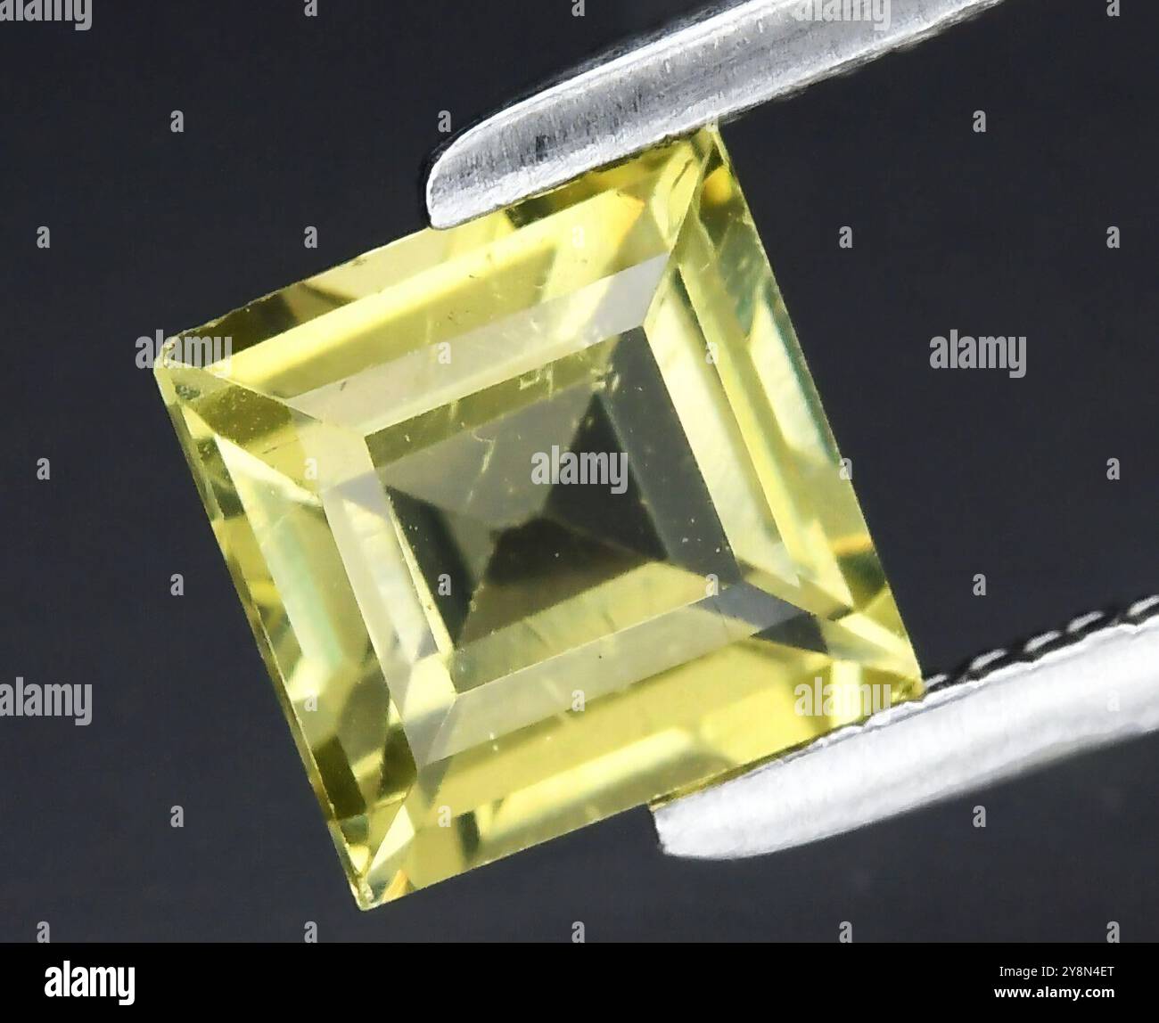 Radiant Yellow Sapphire Gemstone Set in Silver Tweezers Capturing Light ...