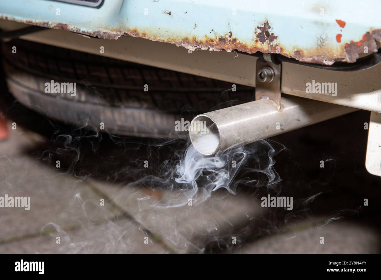 A smoking exhaust tail pipe from an old rusty car showing the smoky ...