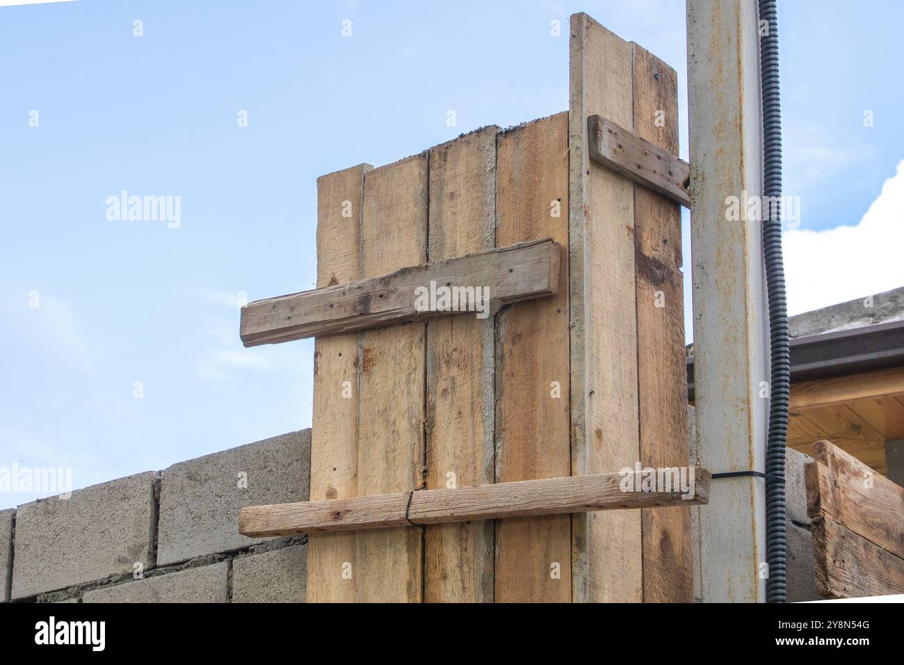 A wooden beam on the side of an industrial building, set up to support ...
