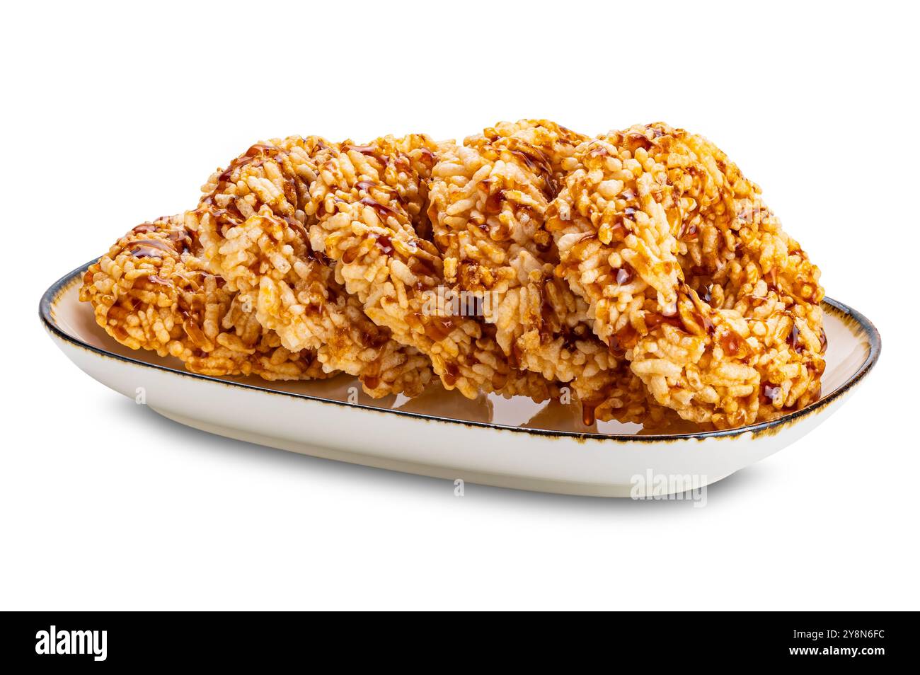 Crispy homemade rice crackers in brown ceramic tray with dark edge ...
