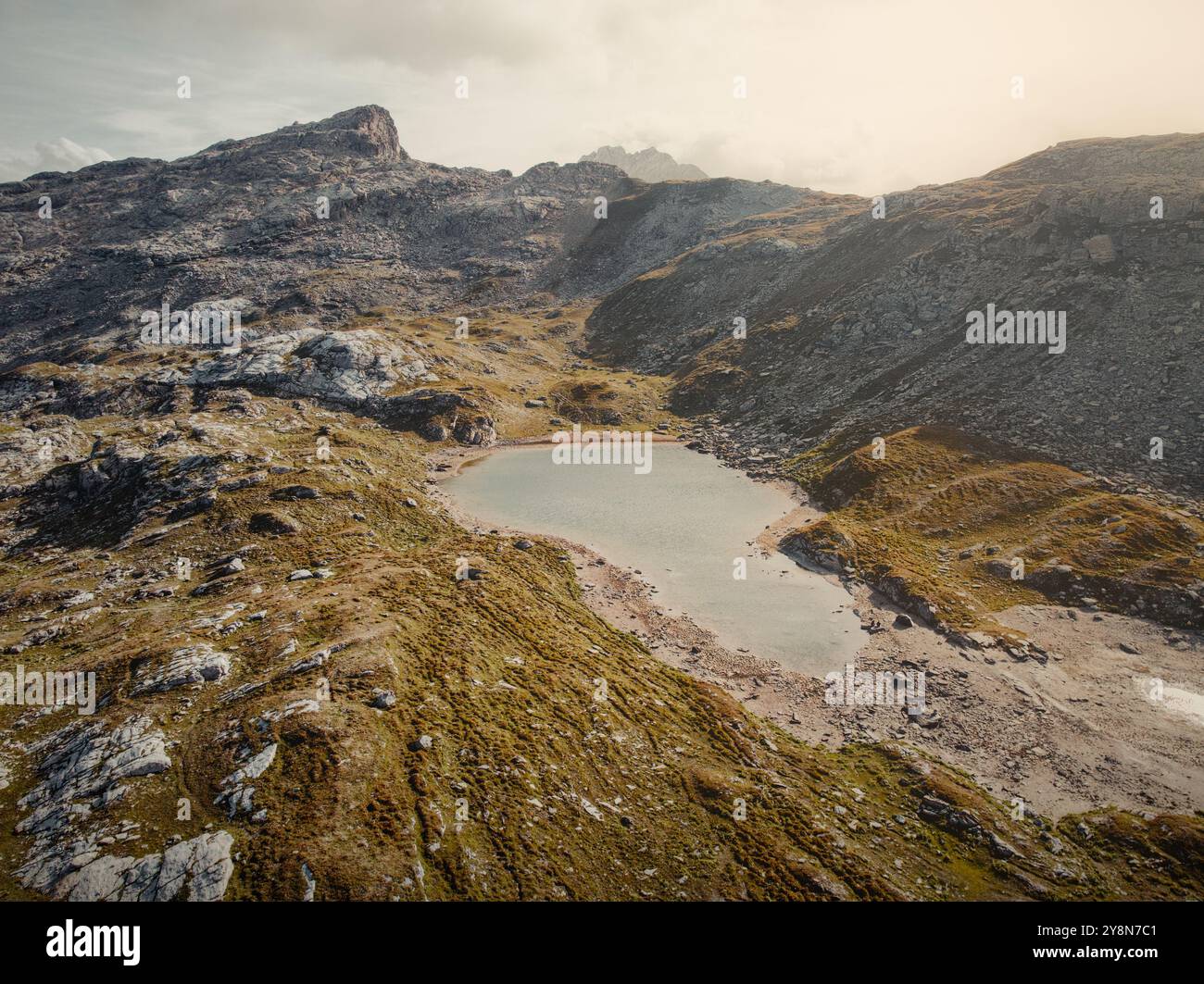 Drone aerial view of the Savognin mountains in Switzerland at sunset, highlighting rugged peaks ...