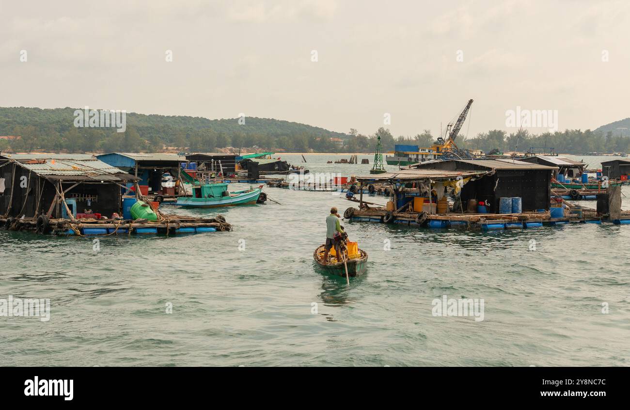 Vietnam, houseboats on the water that are fish farms, there is an ...