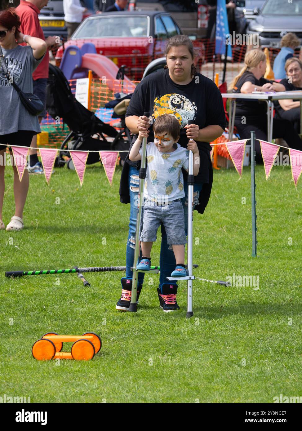 Young child learning to stilt walk during a circus skills workshop ...