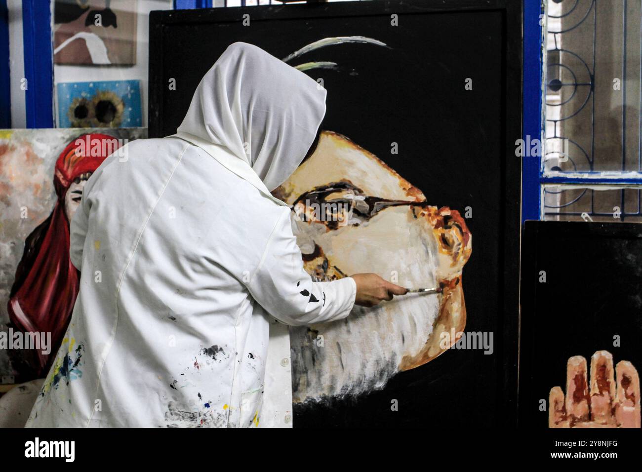 A Palestinian artist paints a portrait of Lebanese Hezbollah leader ...