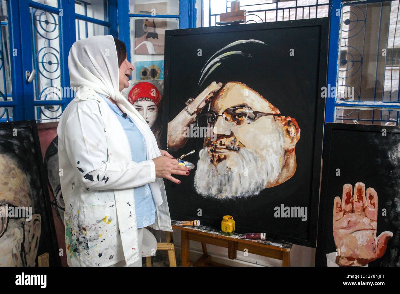A Palestinian artist paints a portrait of Lebanese Hezbollah leader ...
