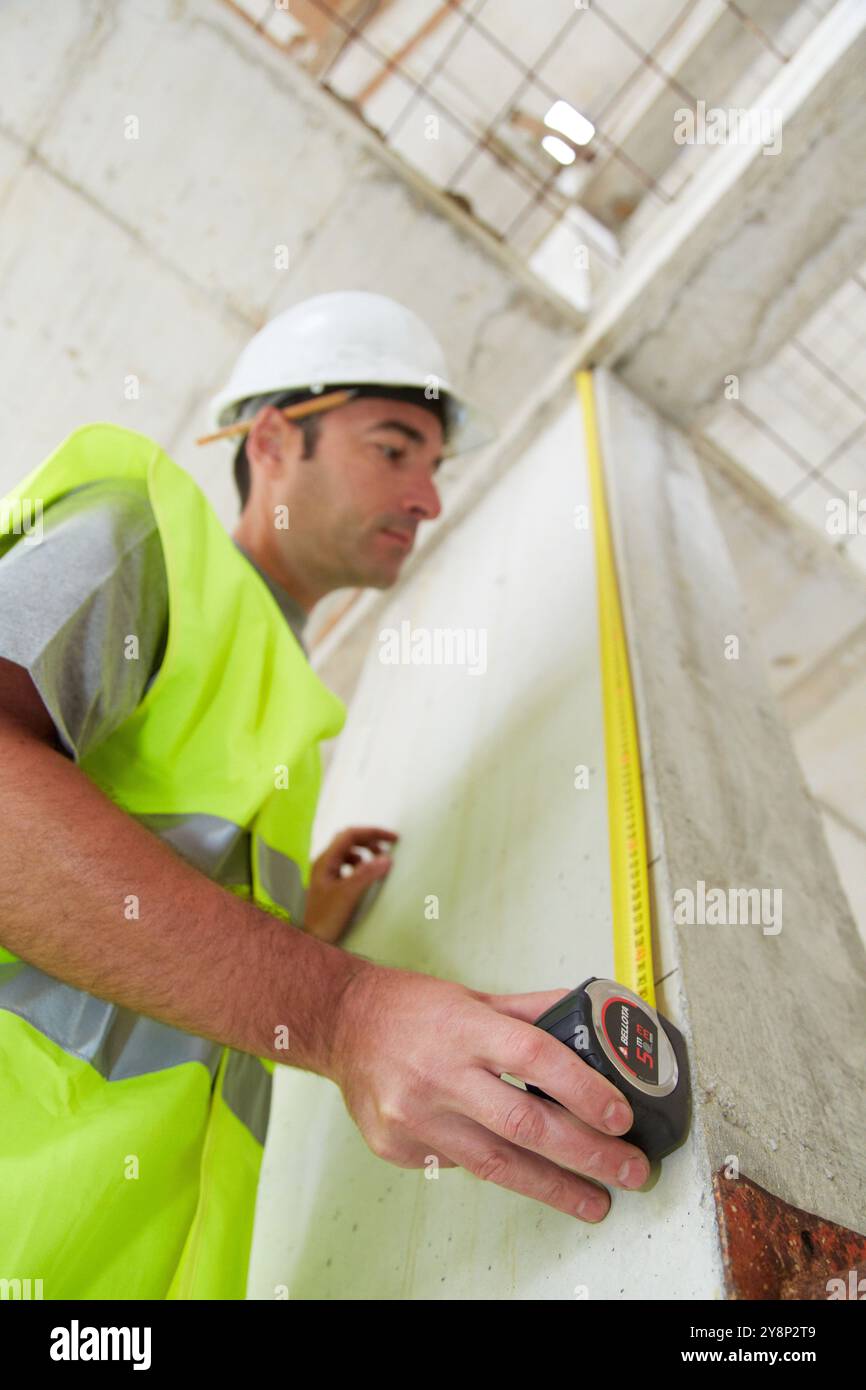 Worker with protective equipment, PPE, Taking measures in concrete beam ...