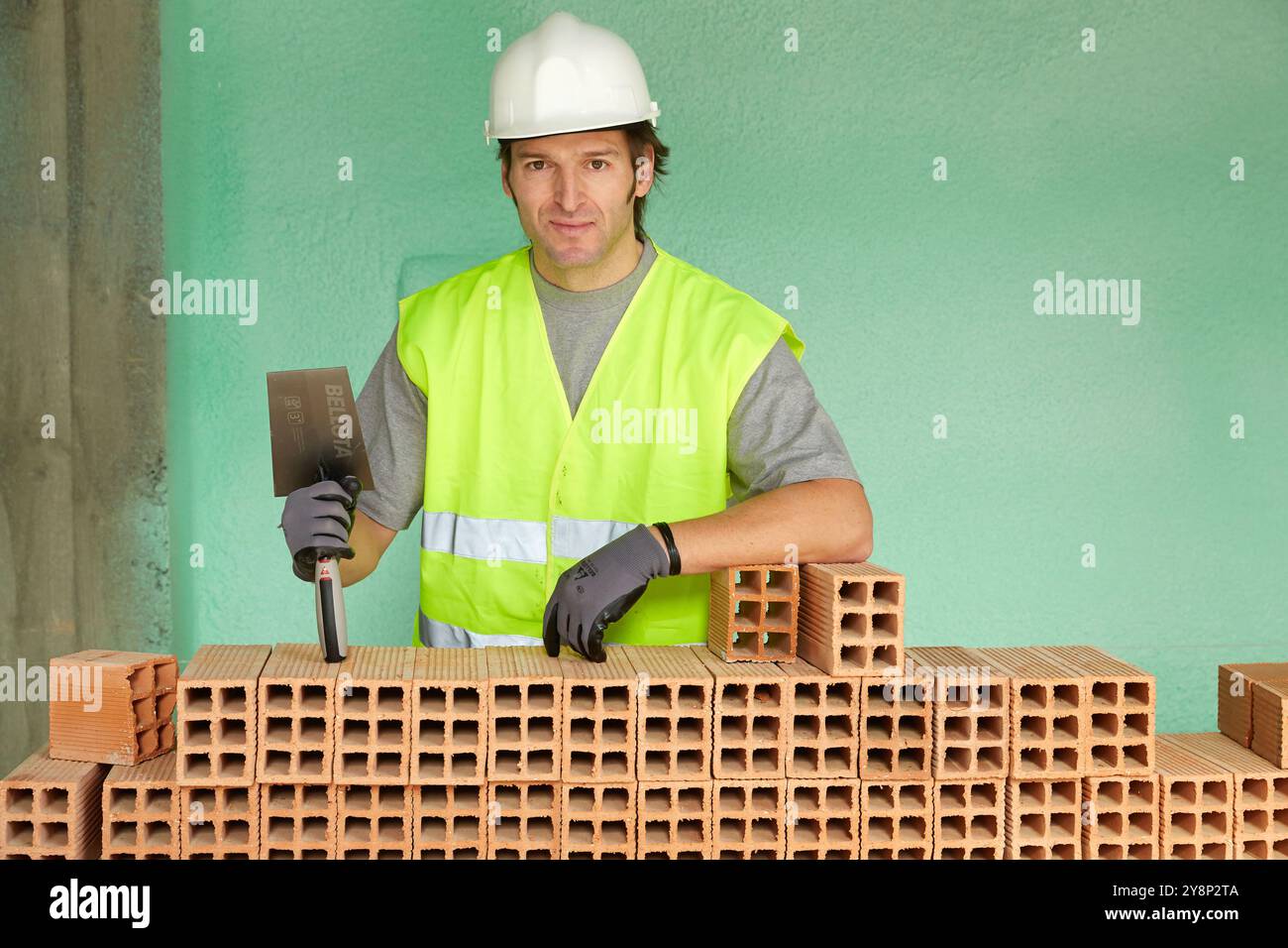 Bricklayer with trowel making a brick wall, Mason with personal ...
