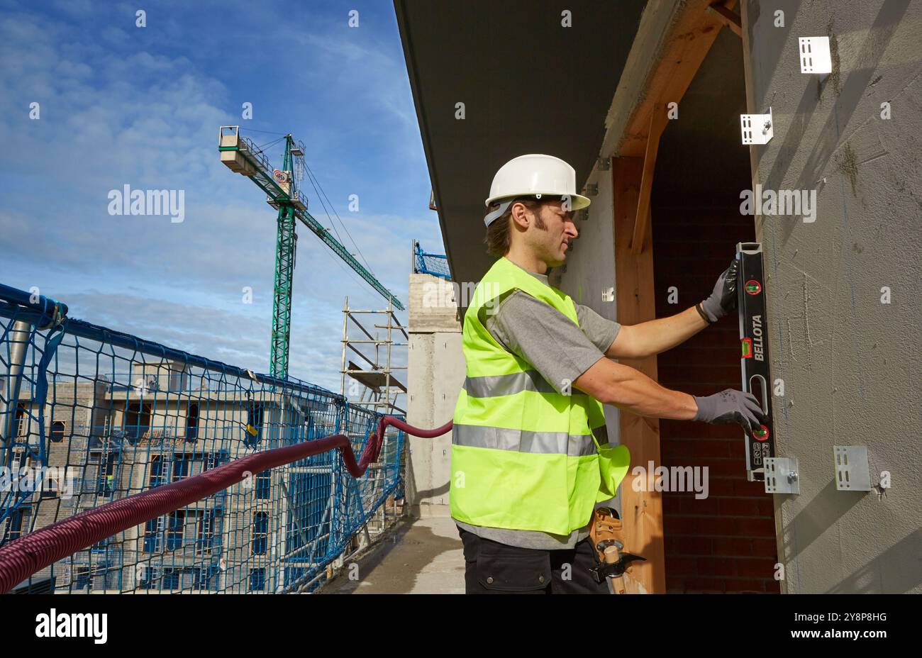 Mason checking the level of a wall, Bricklayer with personal protective ...