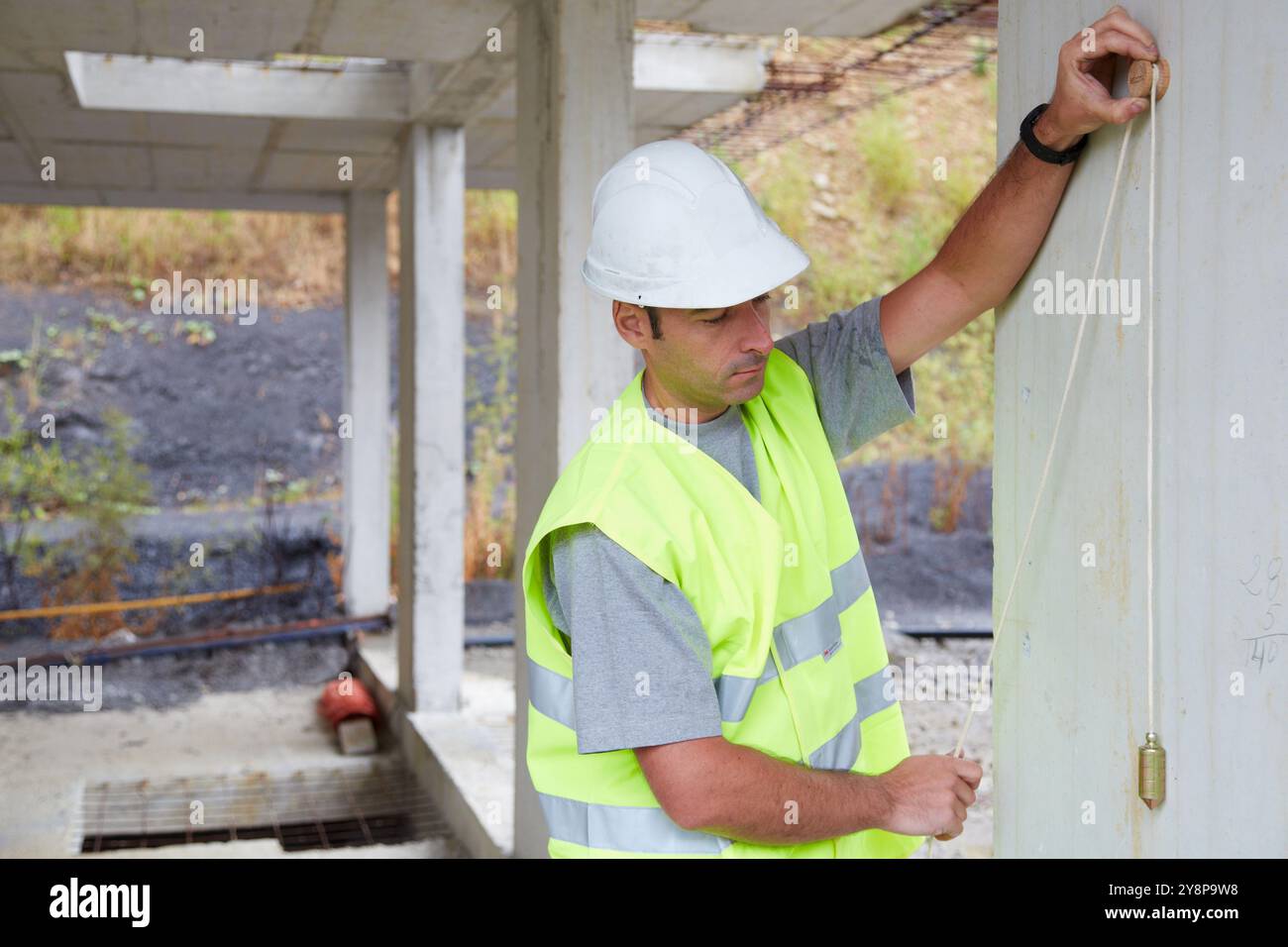 Worker with protective equipment, PPE, Checking and aligning vertical ...